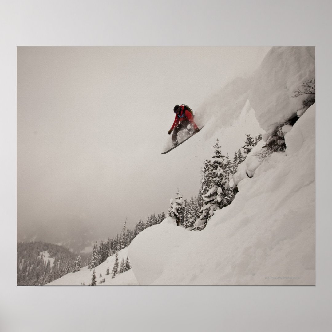 A snowboarder jumps off a cliff into powder in poster | Zazzle