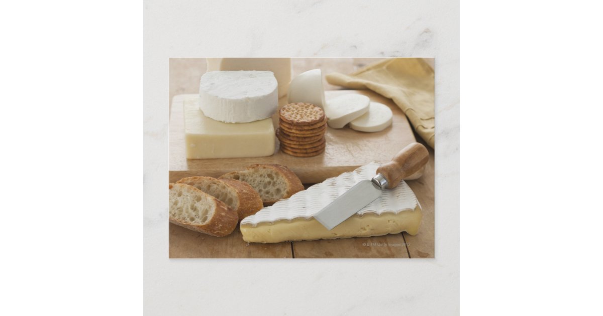 Various cheeses and bread on table postcard | Zazzle